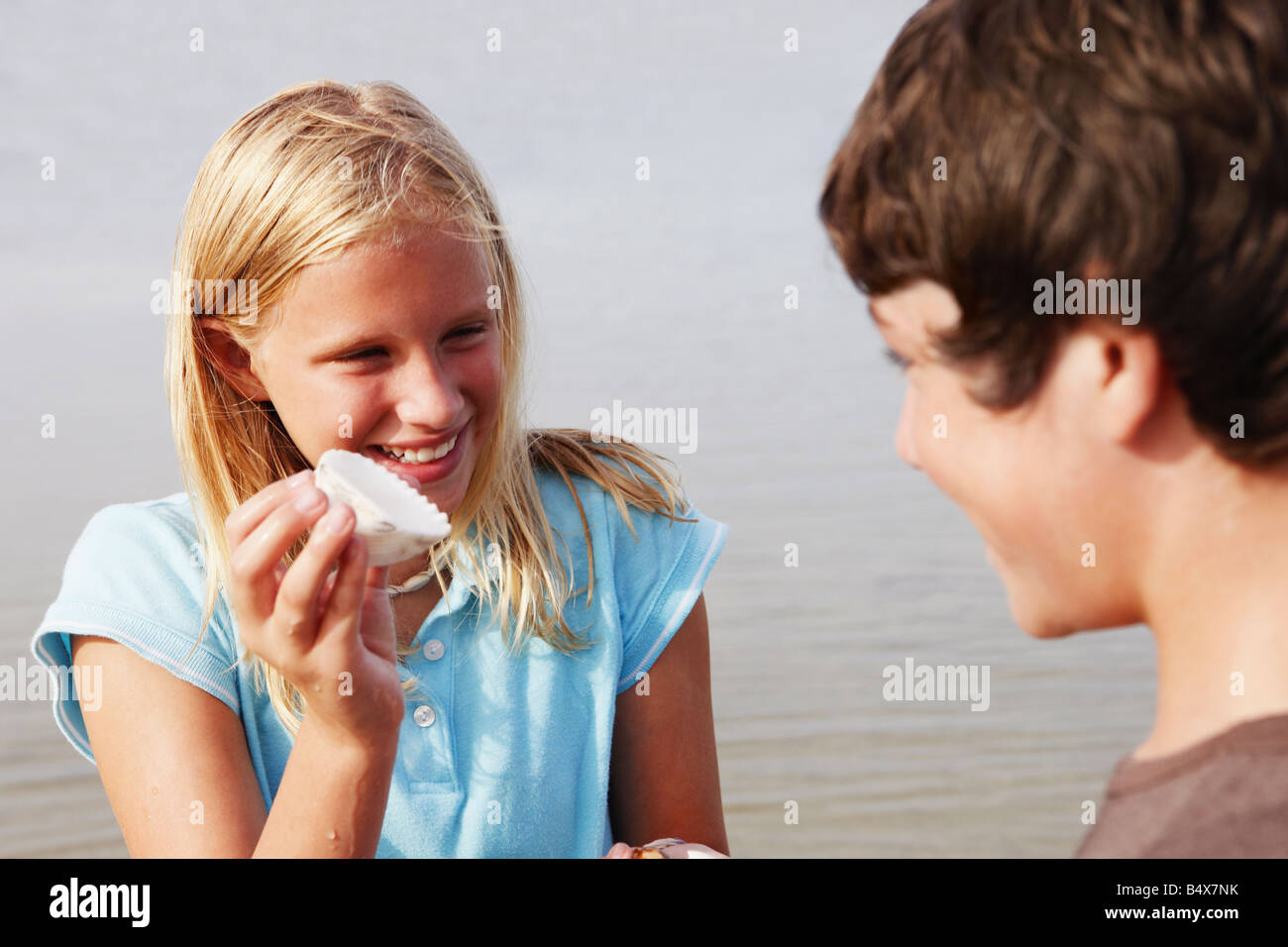 Girl showing shell to friend Stock Photo - Alamy