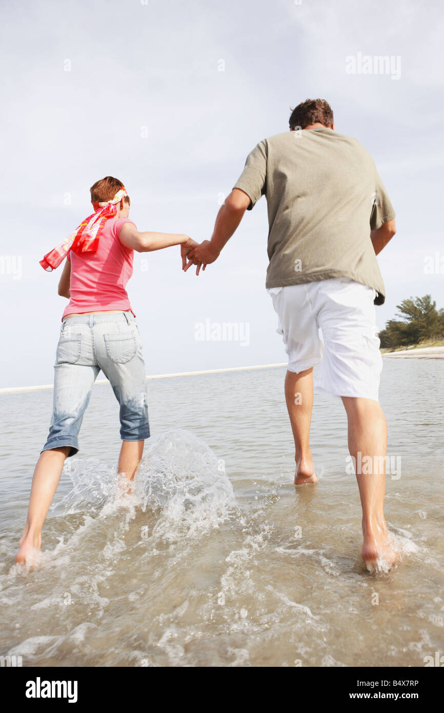Couple running in ocean Stock Photo - Alamy