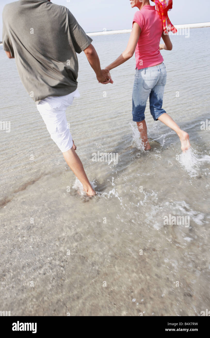 Couple running in ocean Stock Photo - Alamy