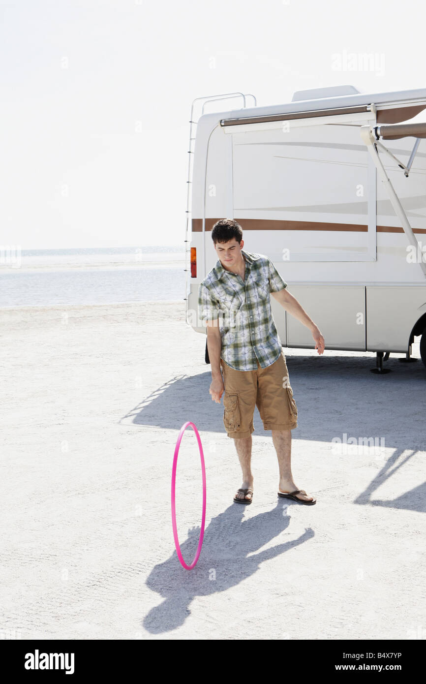 Young man spinning hula hoop on beach Stock Photo - Alamy