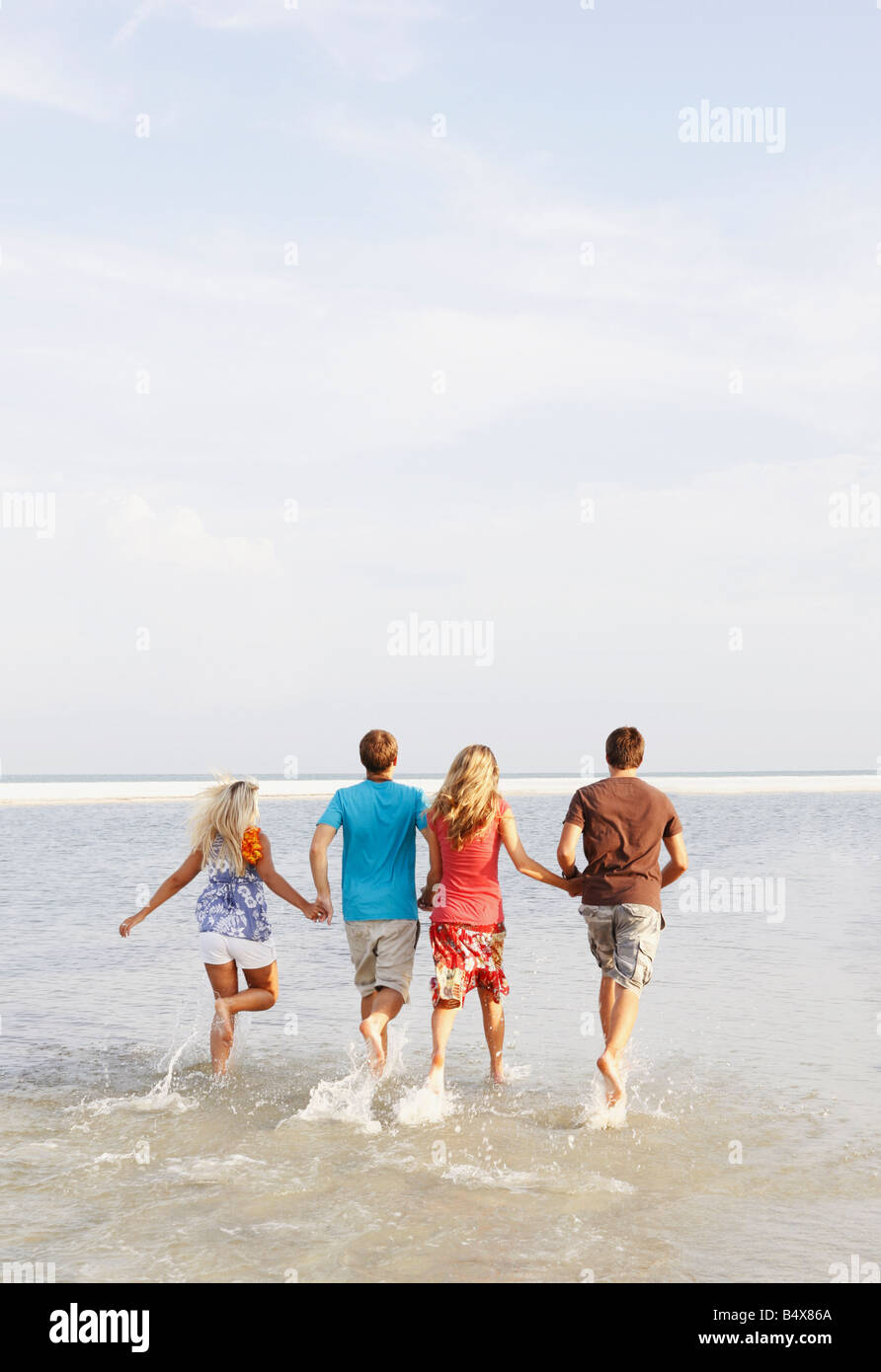 Friends running in ocean Stock Photo - Alamy