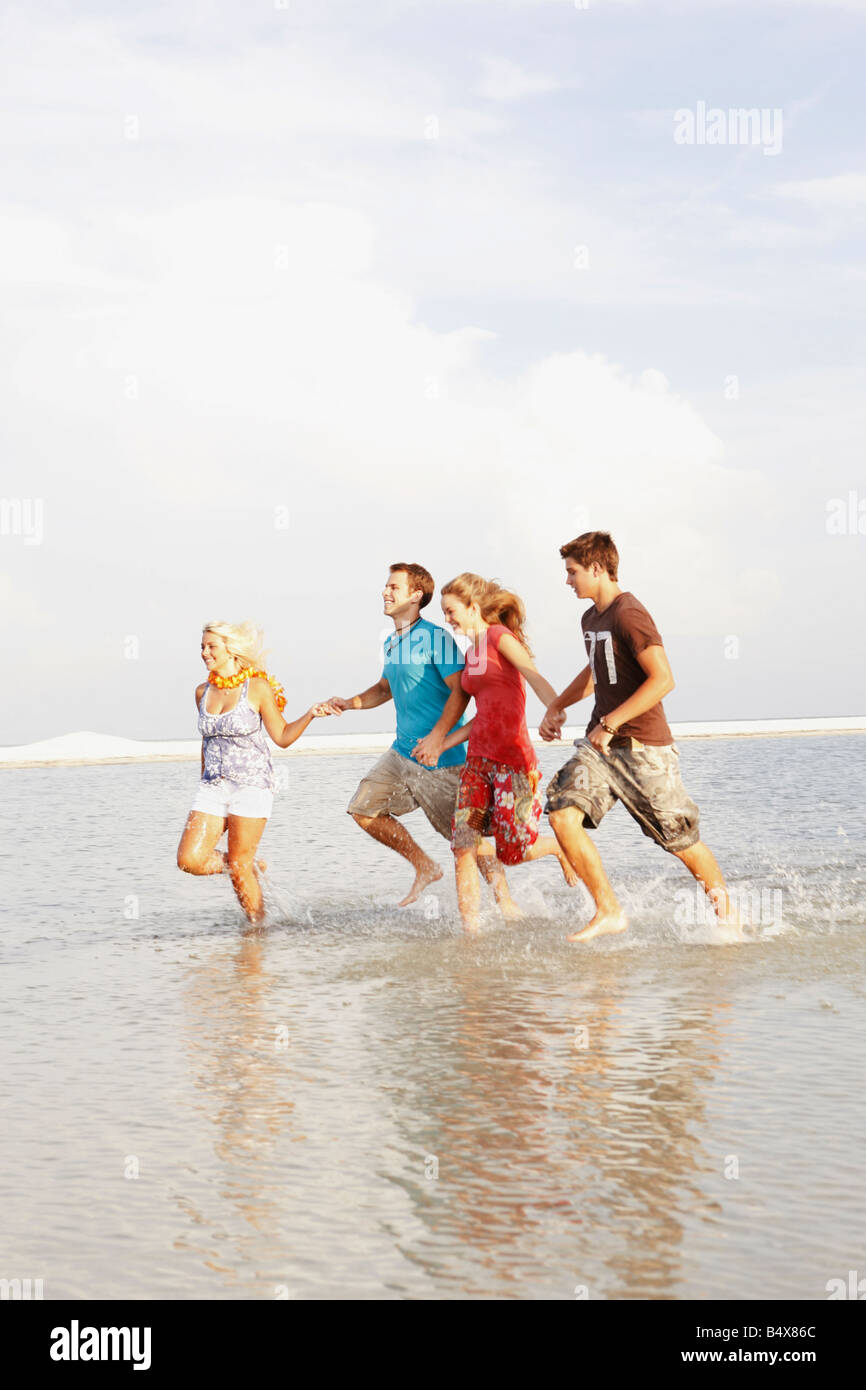 Friends running in ocean Stock Photo - Alamy