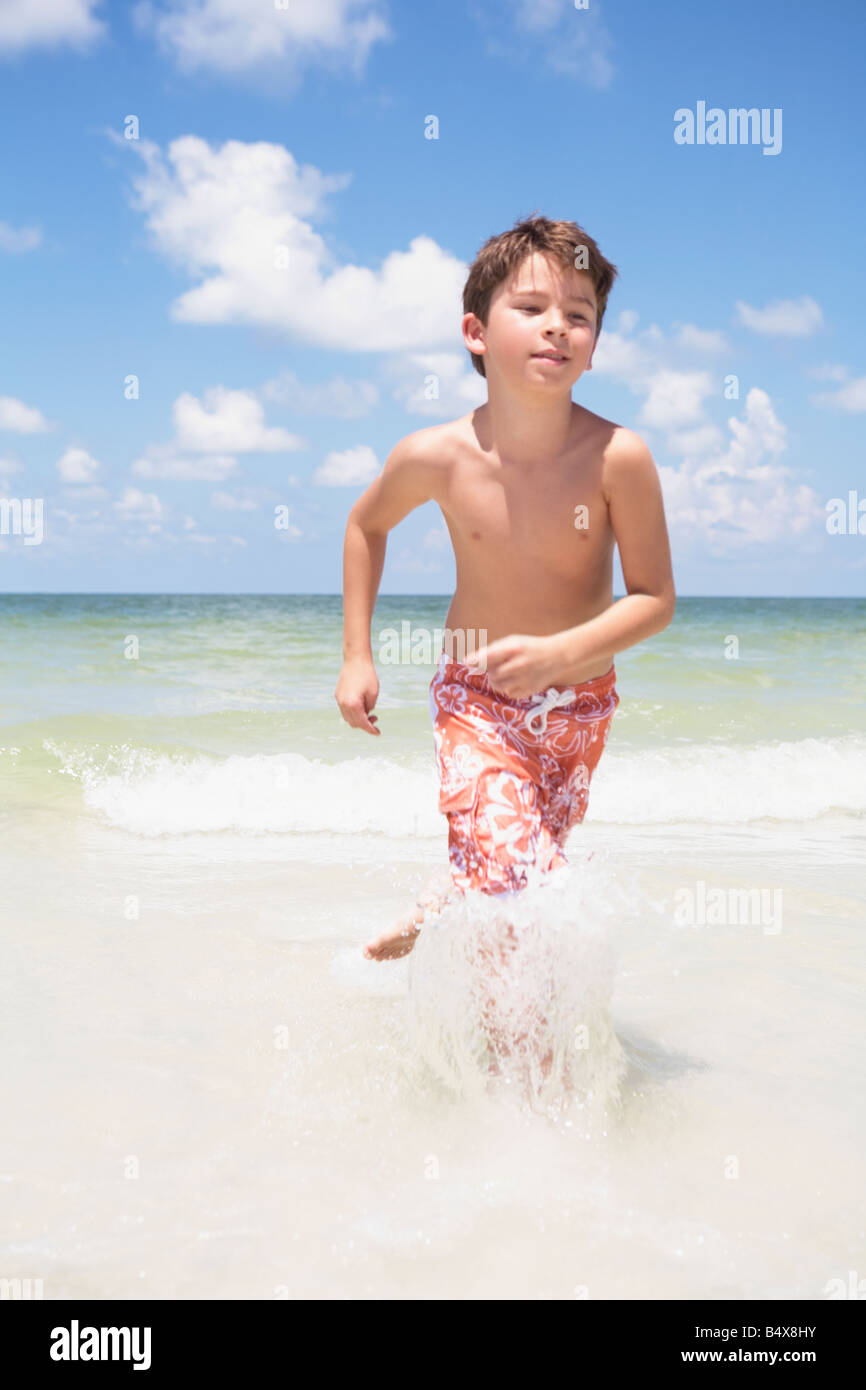Boy running in ocean Stock Photo - Alamy