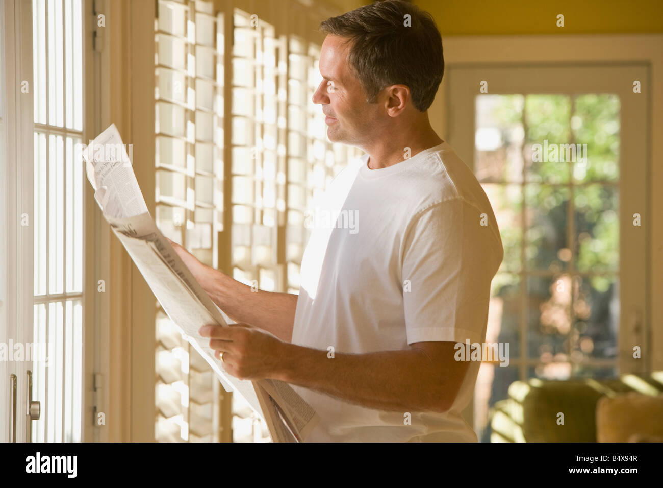 Man reading newspaper in livingroom Stock Photo - Alamy