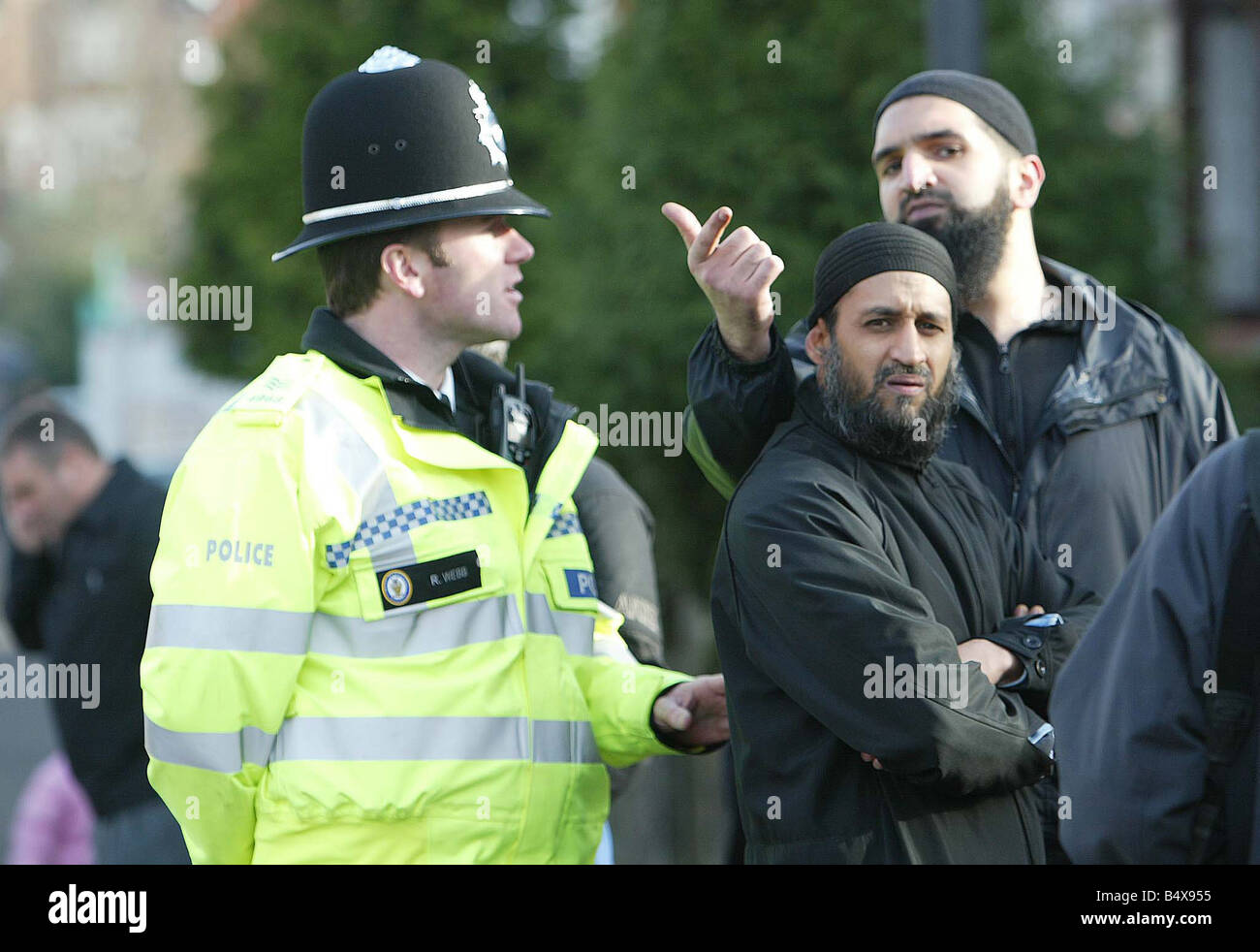 Zia Mahmood brother of arrested man Amjad Mahmood (centre) lead away by ...