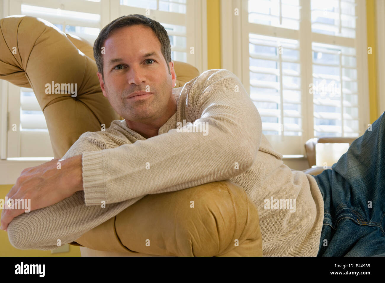 Man relaxing in arm chair Stock Photo - Alamy