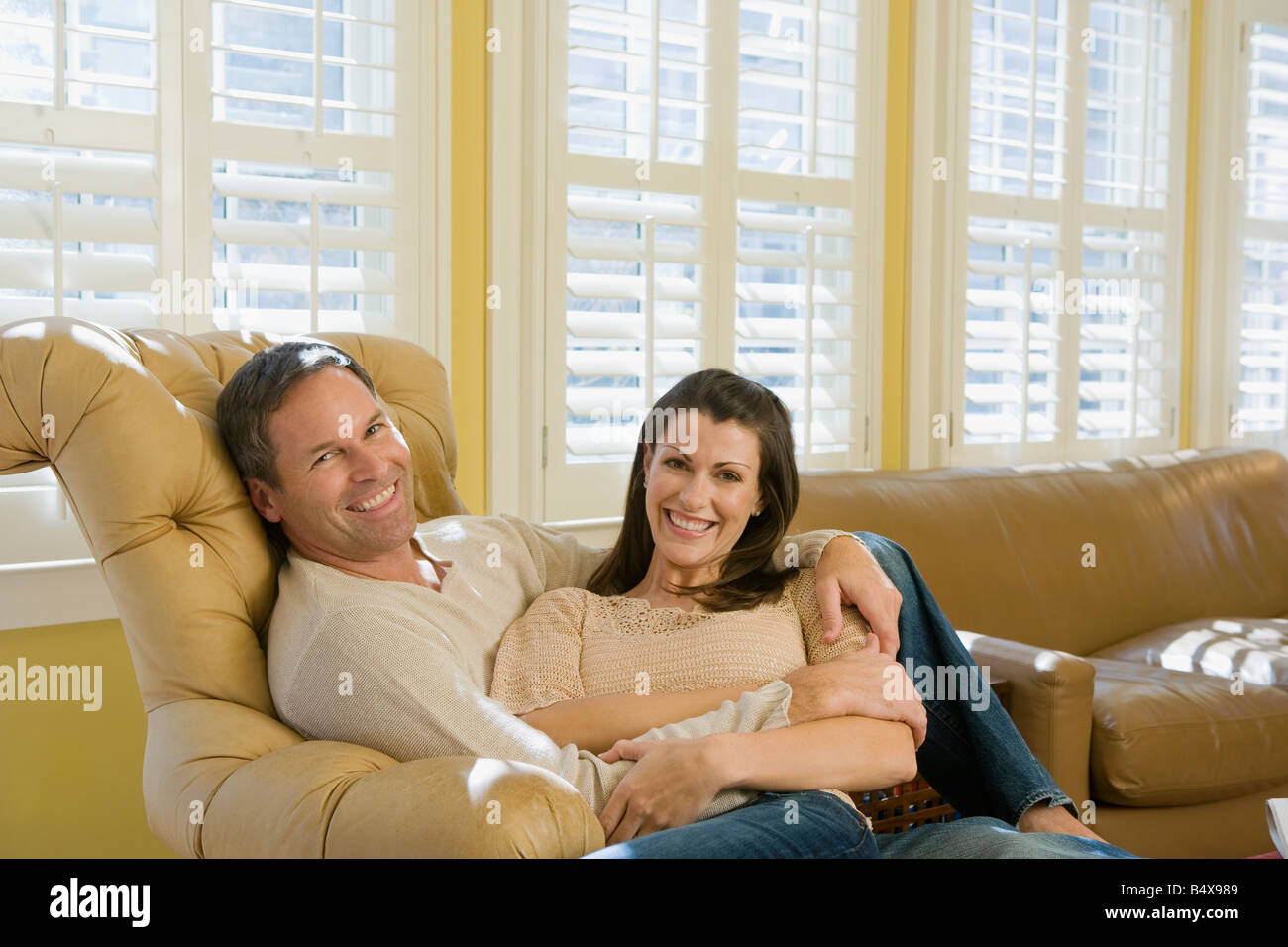 Couple relaxing in livingroom Stock Photo - Alamy