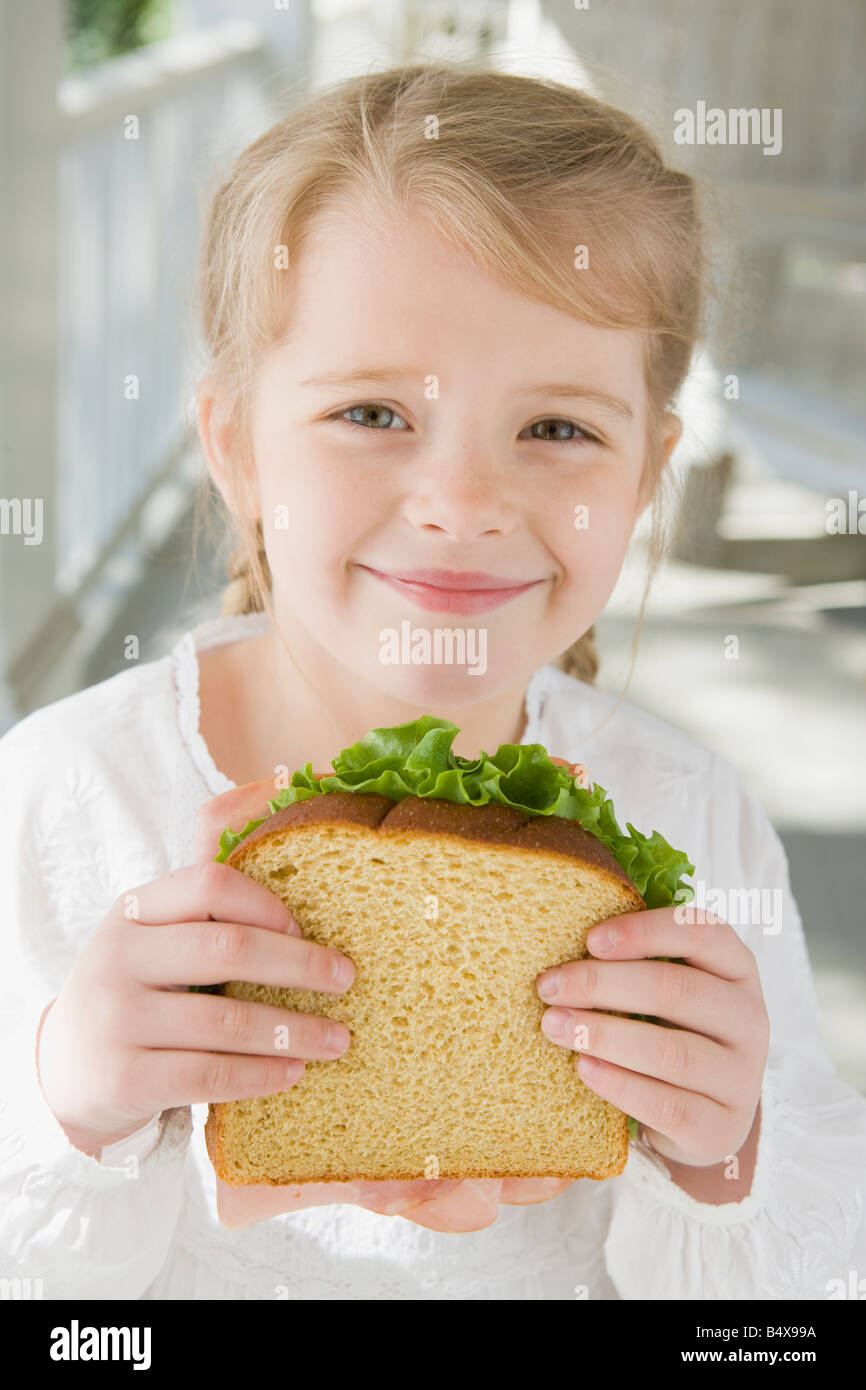 Girl eating sandwich on porch Stock Photo - Alamy