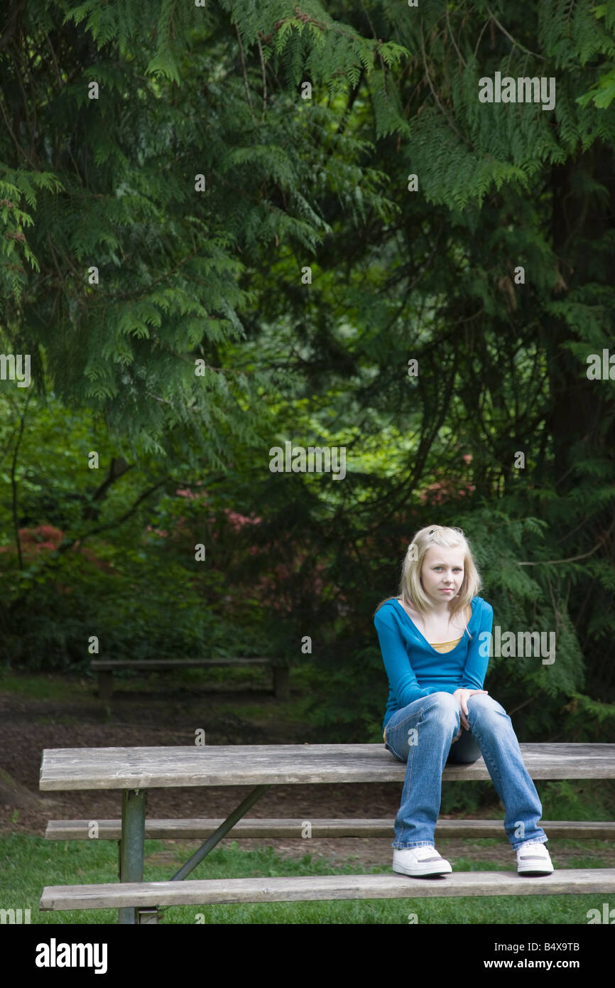 Girl sitting on park bench Stock Photo - Alamy