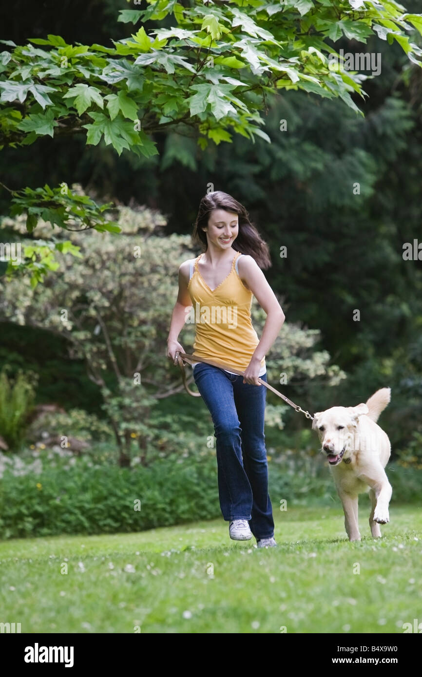 Girl running dog in park Stock Photo - Alamy