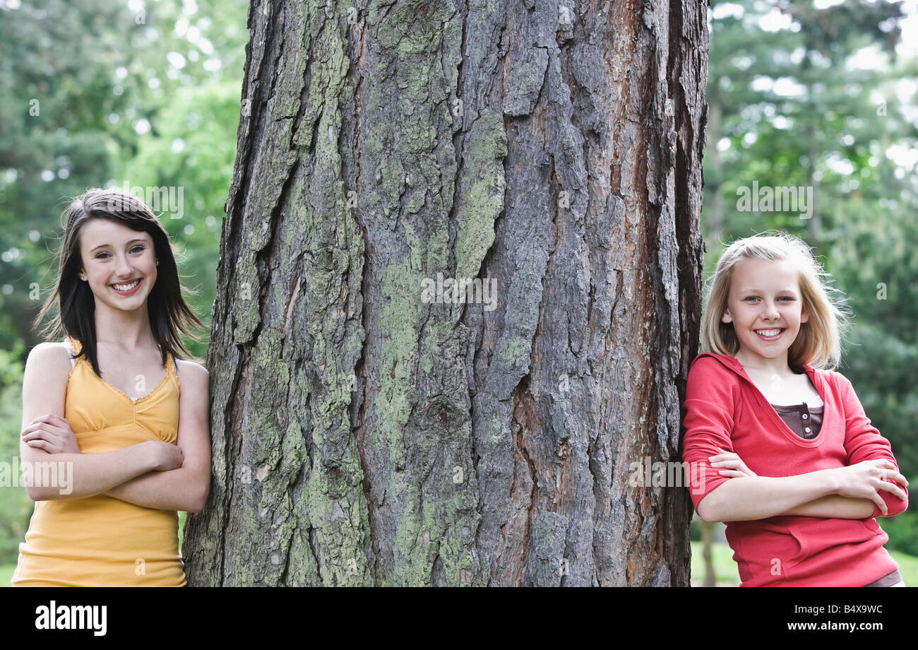 Two girls leaning against tree hi-res stock photography and images - Alamy