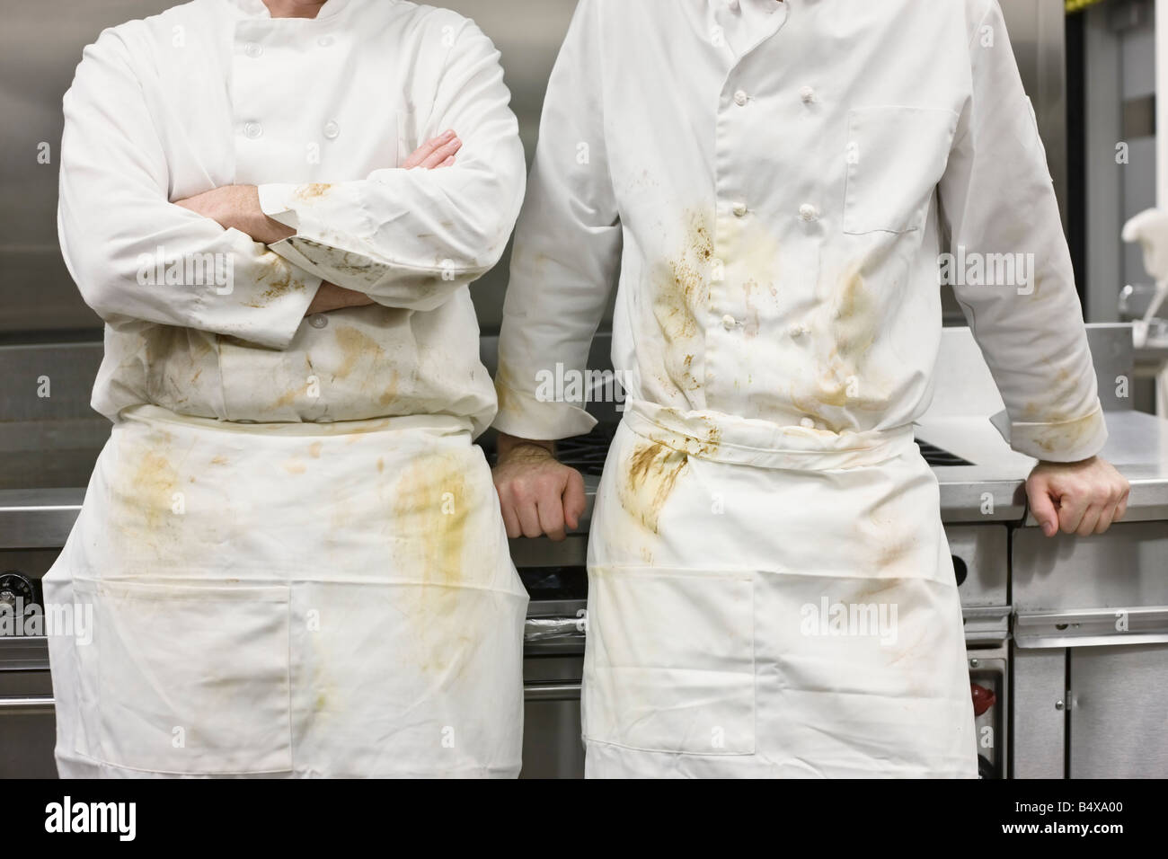 Dirty chefs leaning against stove Stock Photo - Alamy