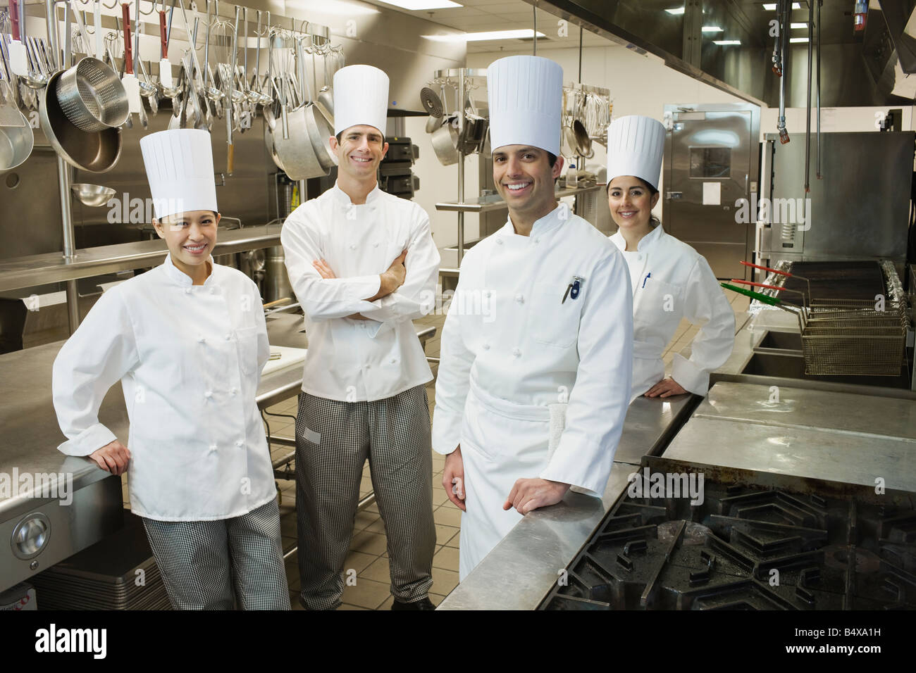Chefs posing in kitchen Stock Photo - Alamy