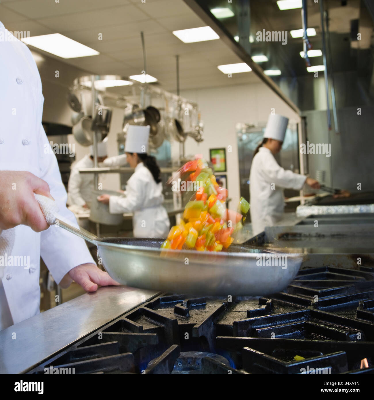 Chef tossing food in skillet Stock Photo - Alamy