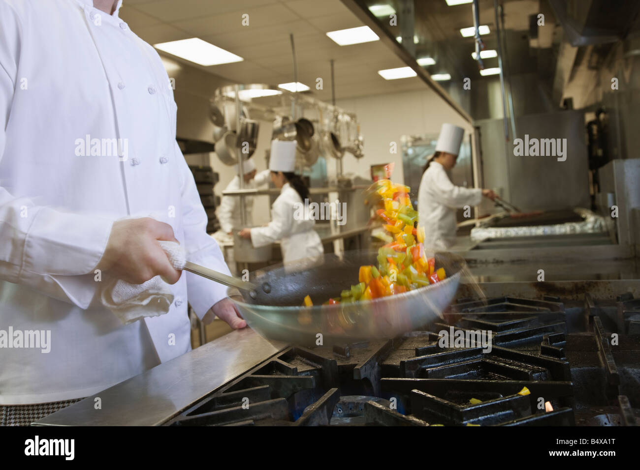 Chef tossing food in skillet Stock Photo - Alamy