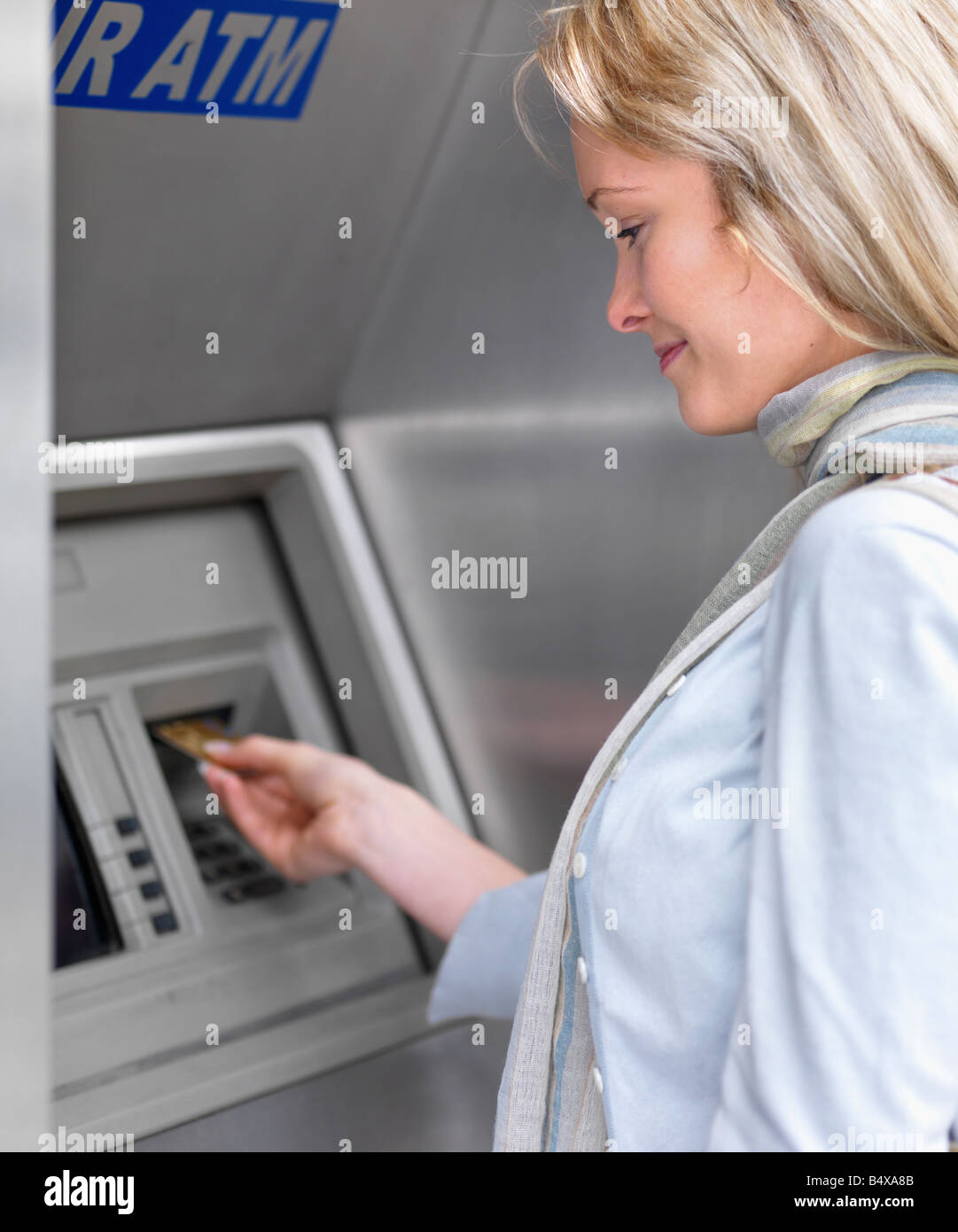 Woman using cash machine Stock Photo - Alamy