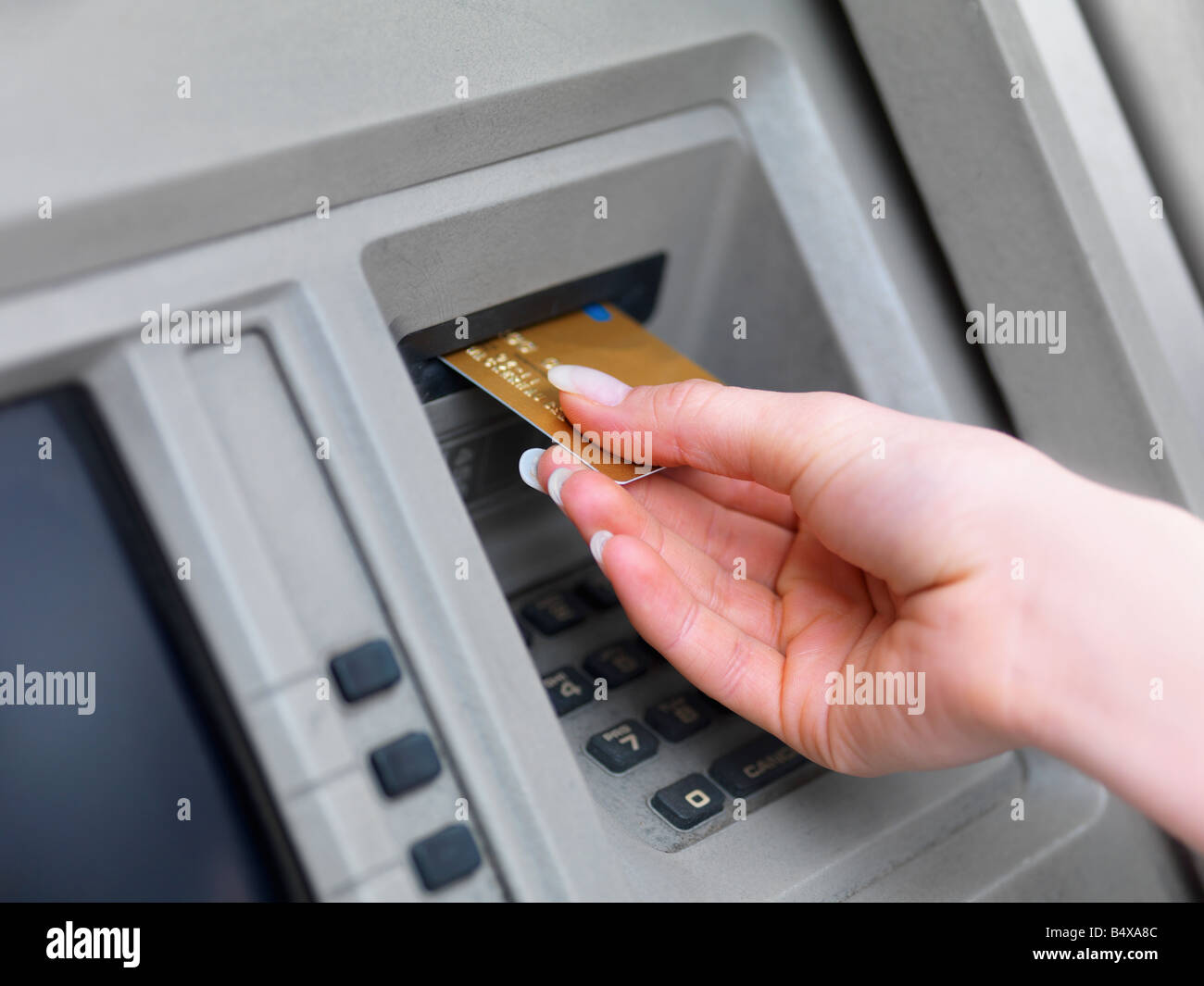 Woman using cash machine Stock Photo - Alamy