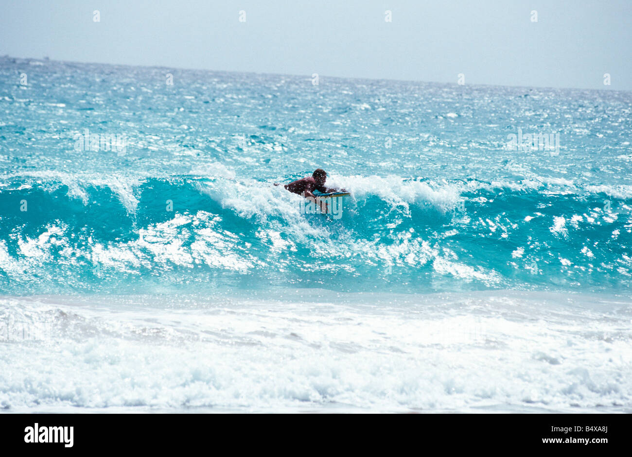 Boogie boarder riding the surf break off Saline beach St. Barths French ...