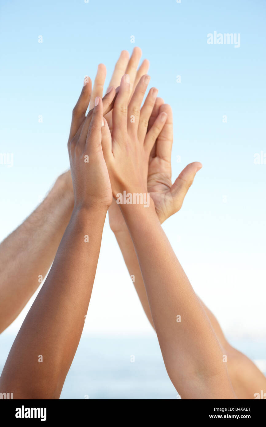 Young friends high fiving on beach Stock Photo - Alamy