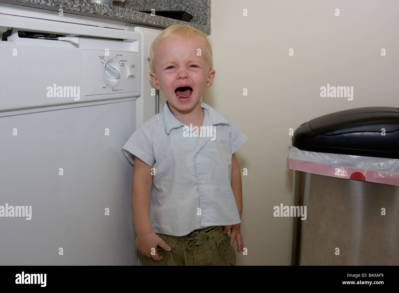 Baby boy crying in kitchen Stock Photo - Alamy
