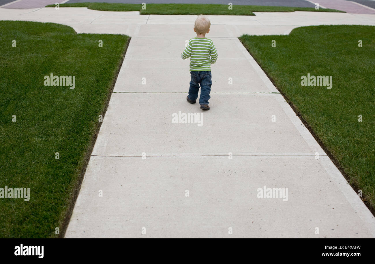 Baby boy walking on sidewalk Stock Photo - Alamy