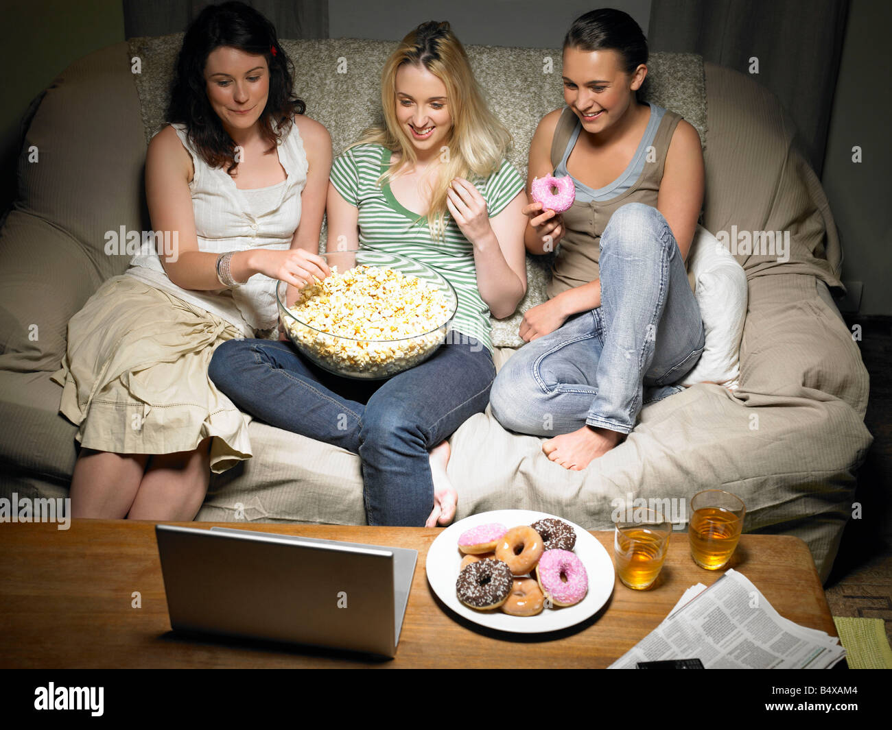 Three young women watching movie Stock Photo - Alamy