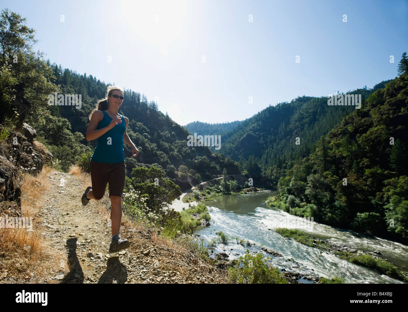 Woman running on riverside trail Stock Photo - Alamy