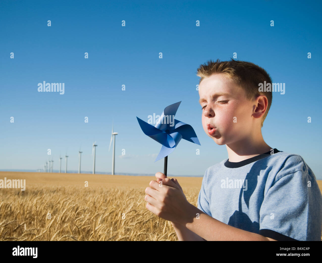 Boy blowing on pinwheel hi-res stock photography and images - Alamy