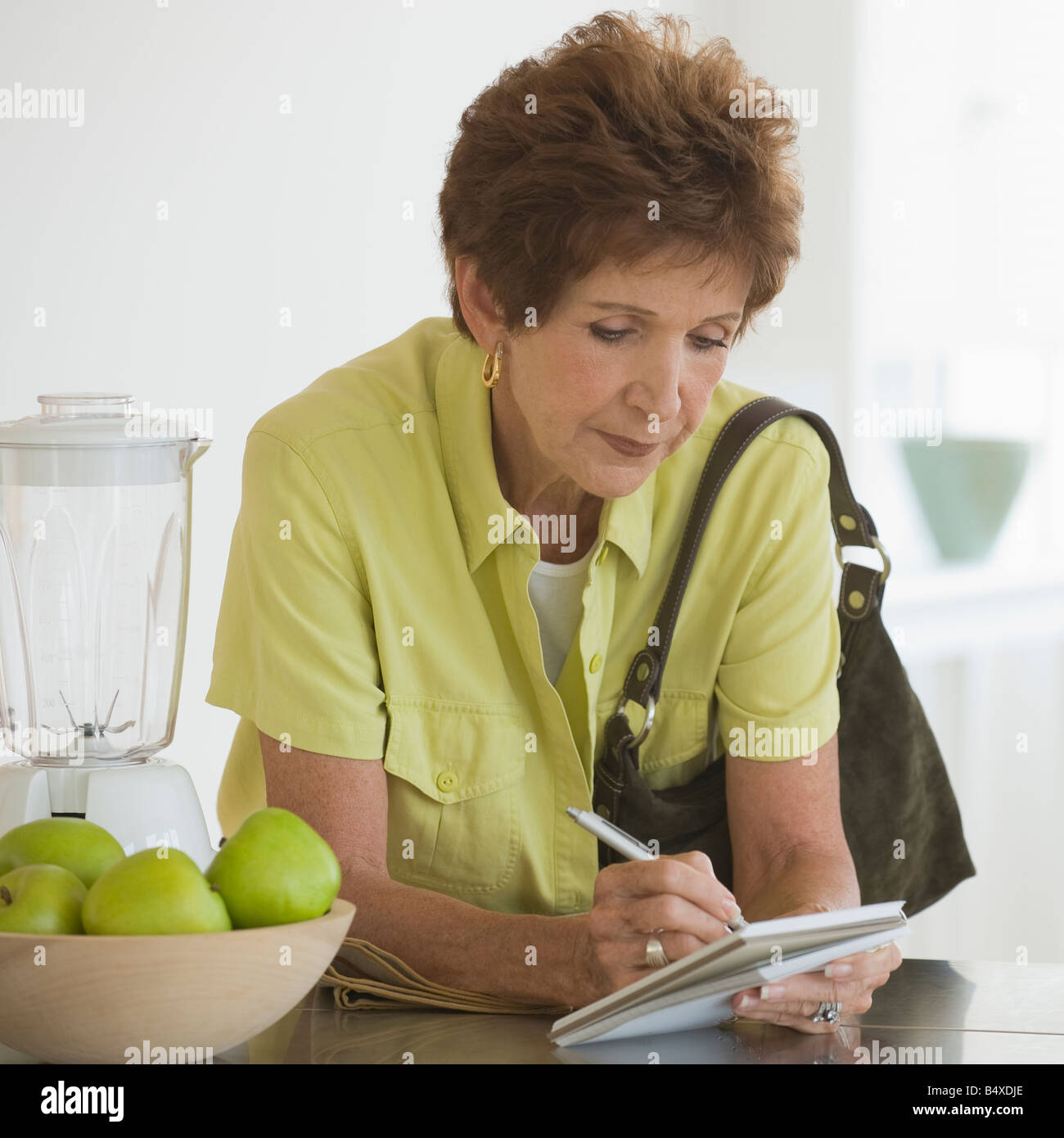 Senior woman writing list Stock Photo - Alamy
