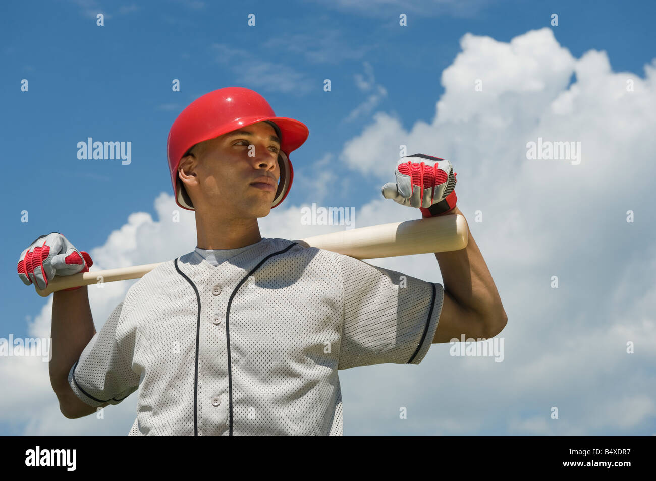 Baseball player holding bat Stock Photo - Alamy