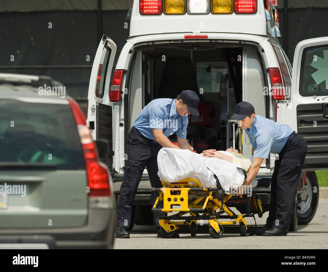 EMTs loading patient into ambulance Stock Photo - Alamy