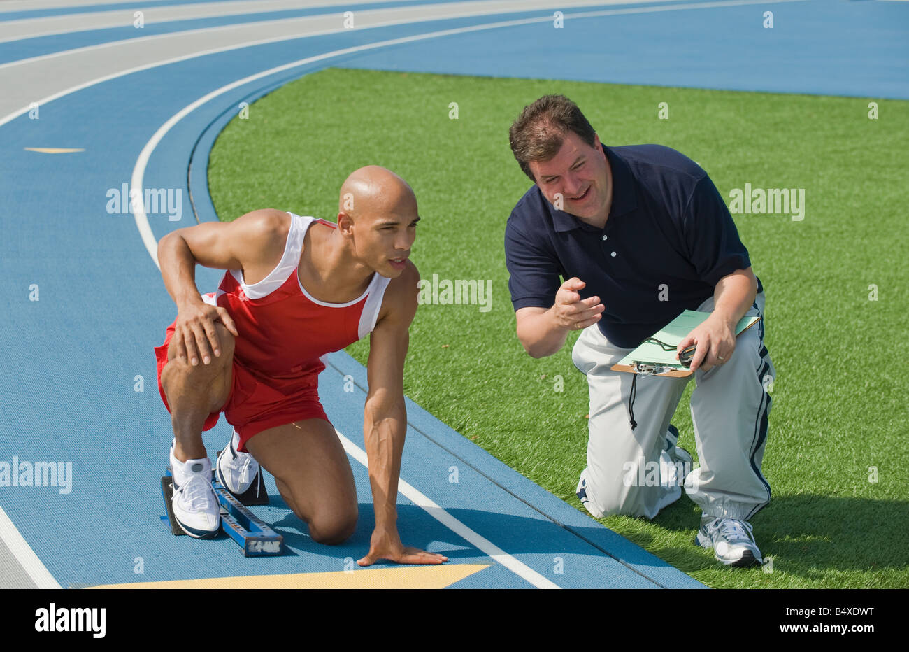 Coach giving runner advise Stock Photo - Alamy