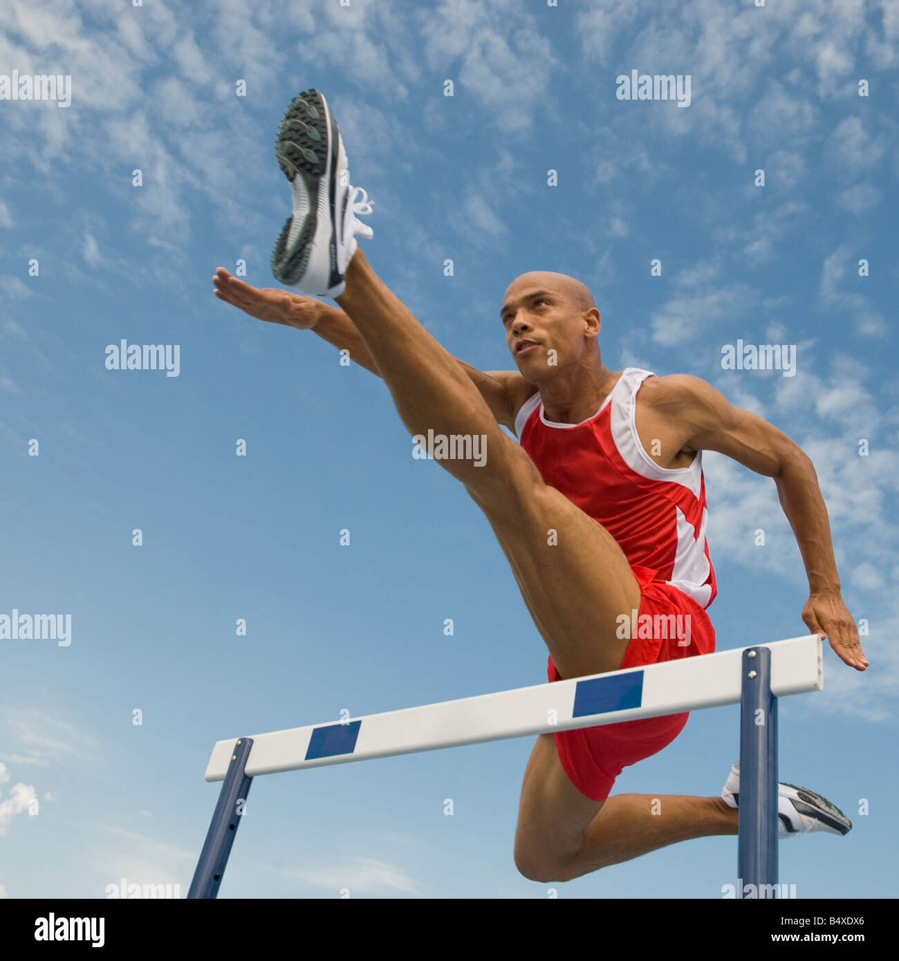 Runner jumping over hurdle Stock Photo - Alamy