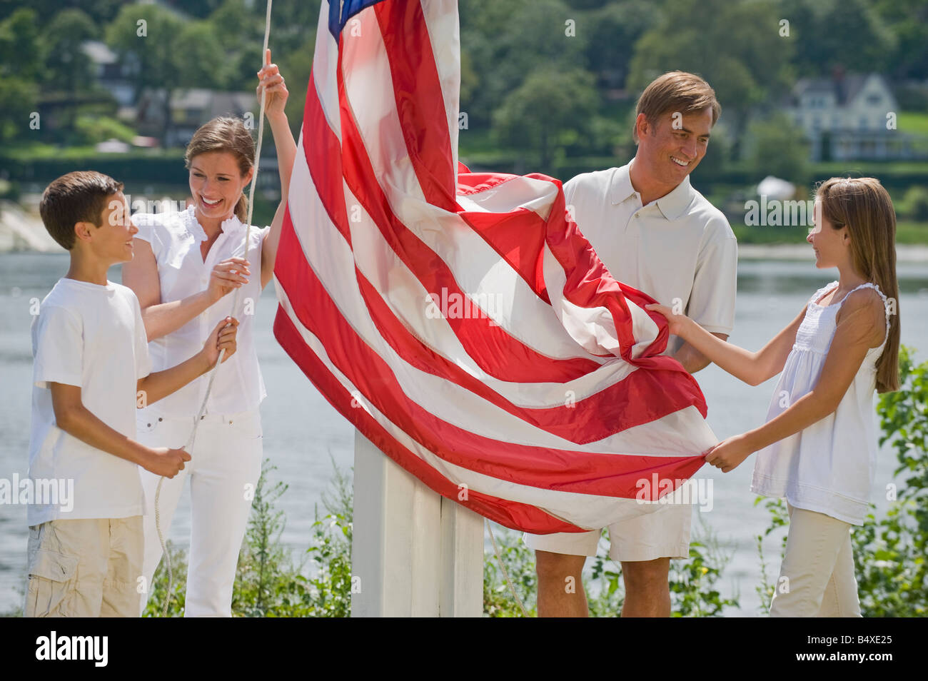 Family raising American flag together Stock Photo - Alamy