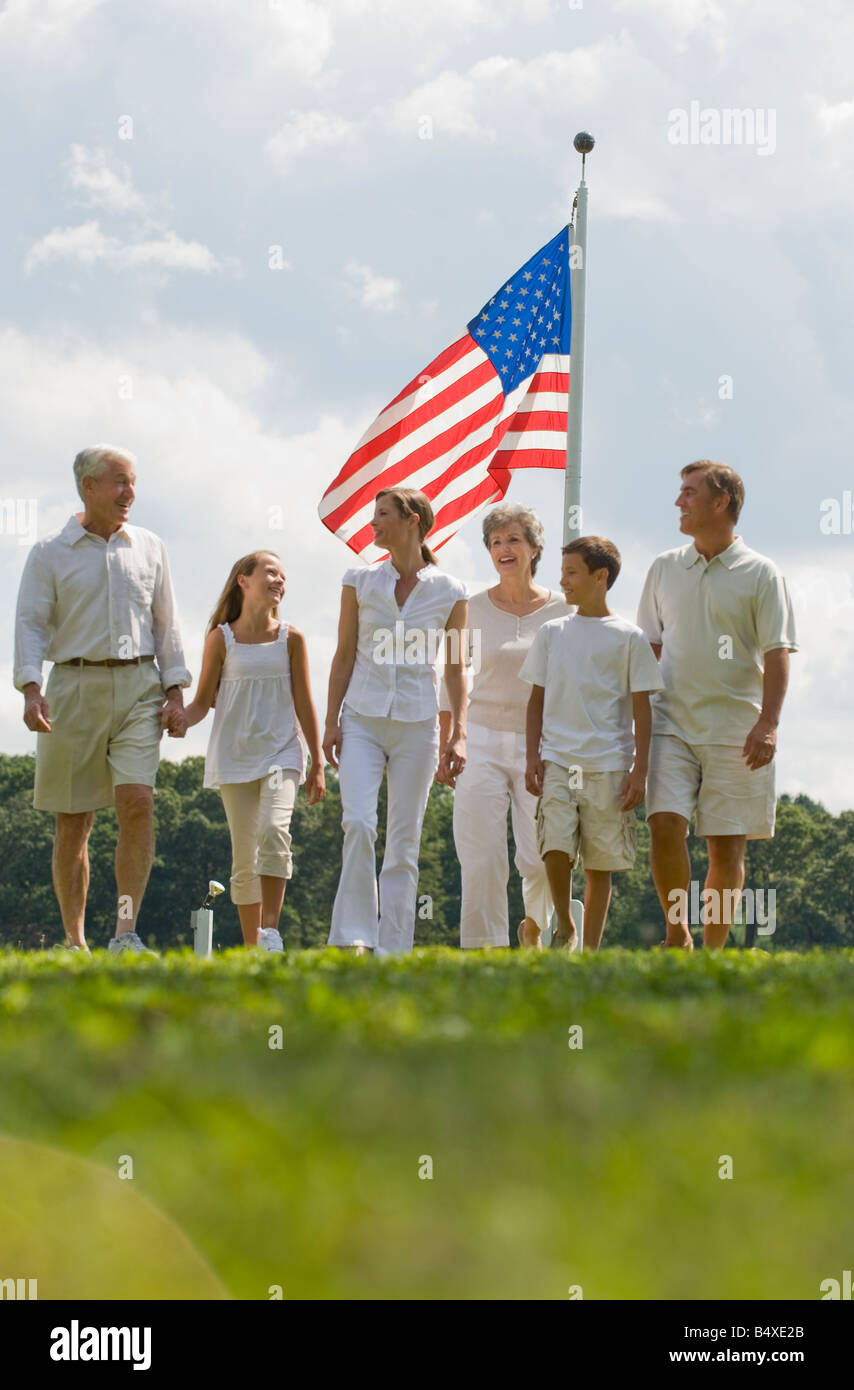 Multi-generational family walking in front of American flag Stock Photo ...