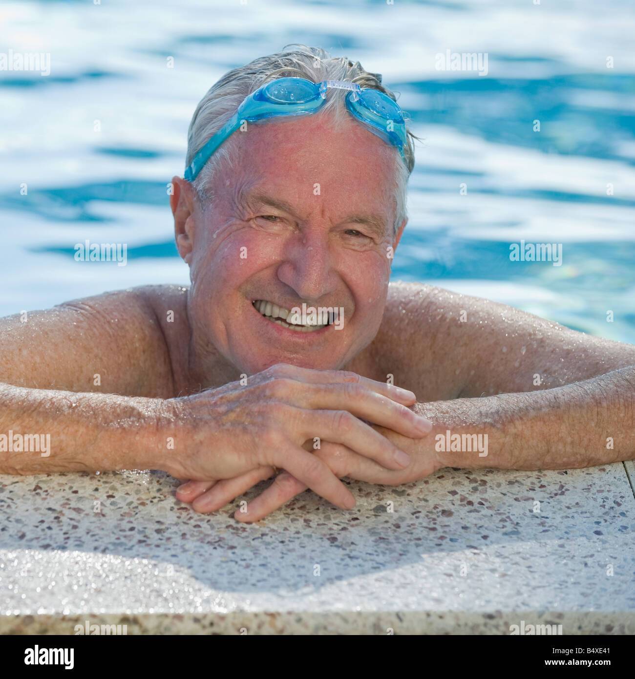 Senior man resting on edge of swimming pool Stock Photo - Alamy