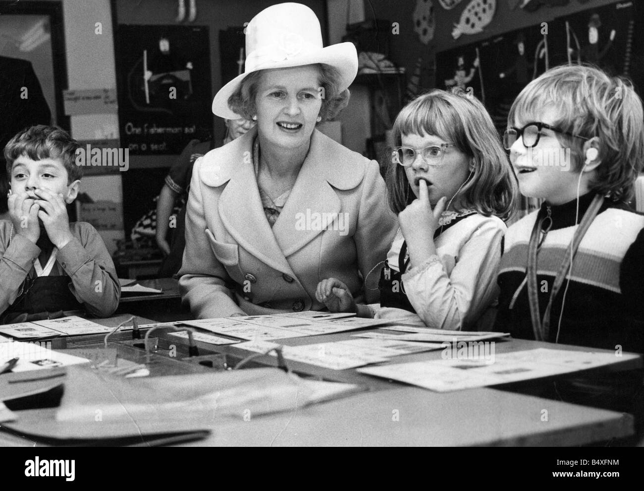 Margaret Thatcher sits with children taking a reading class at the ...
