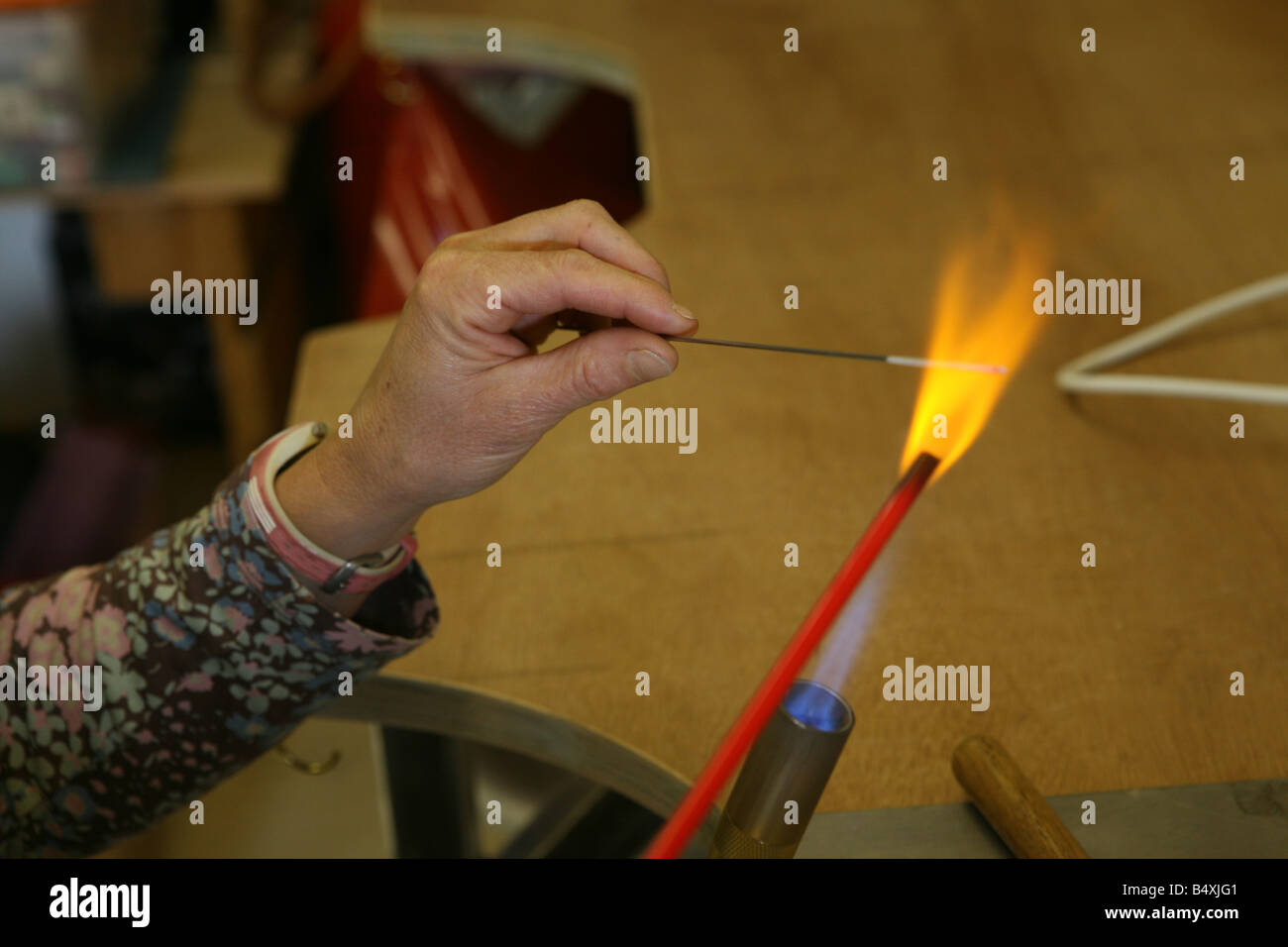 a female silversmith working on some jewelry rings and stuff in her ...