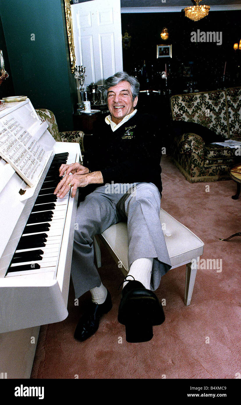 Frankie Vaughan singer piano leaning back on stool leg up Stock Photo ...
