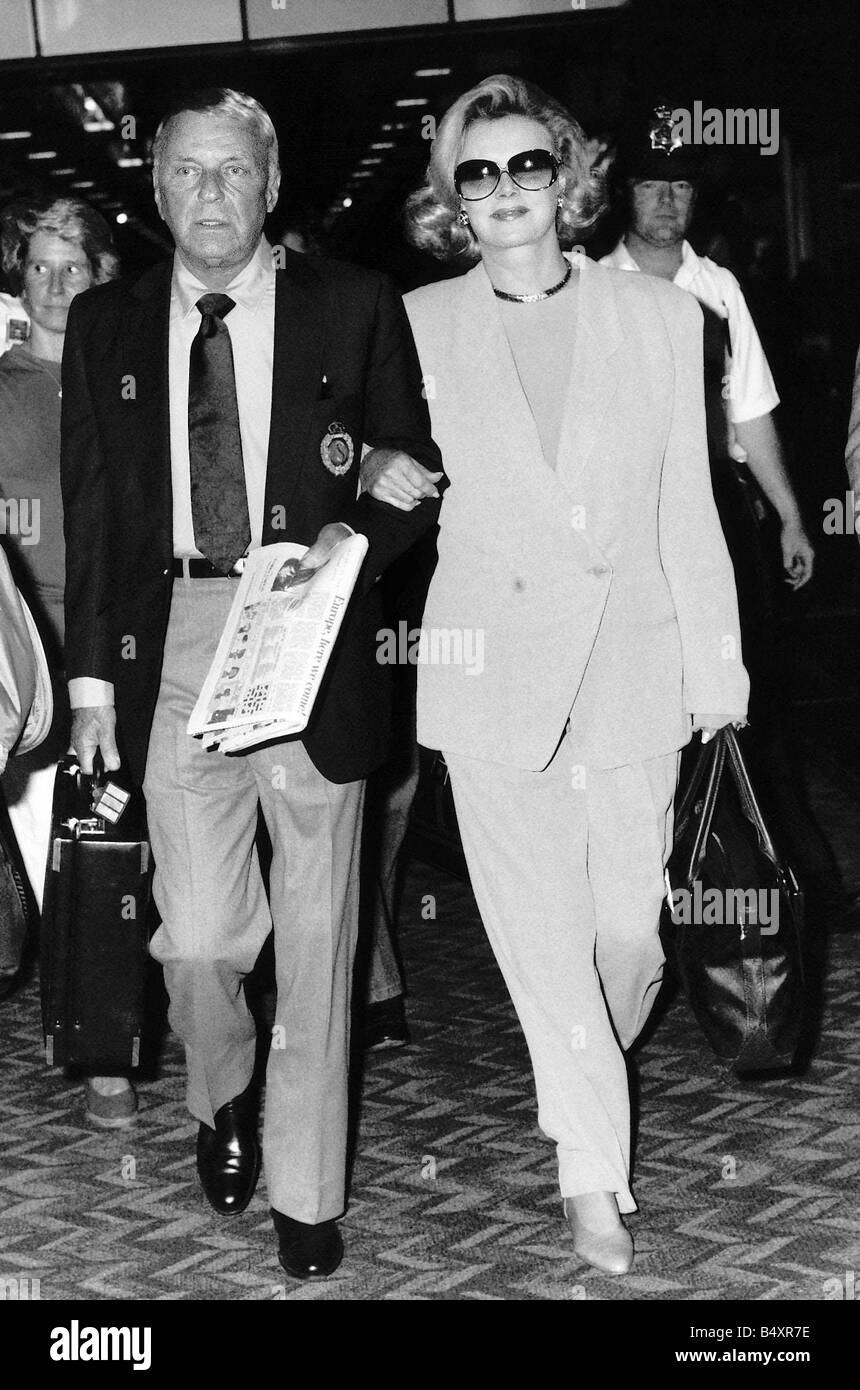 Frank Sinatra Walking with a woman holding a case and a newspaper Stock ...