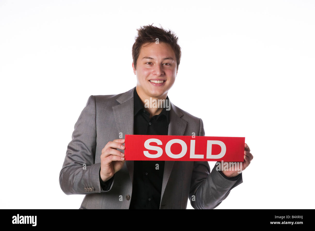 Business man holding a SOLD sign isolated against white background ...