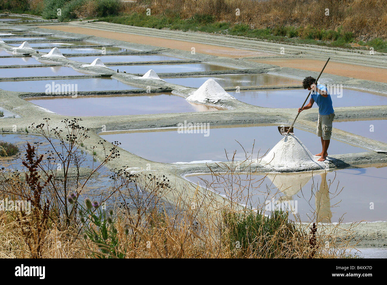 Man working at salt flat Stock Photo - Alamy