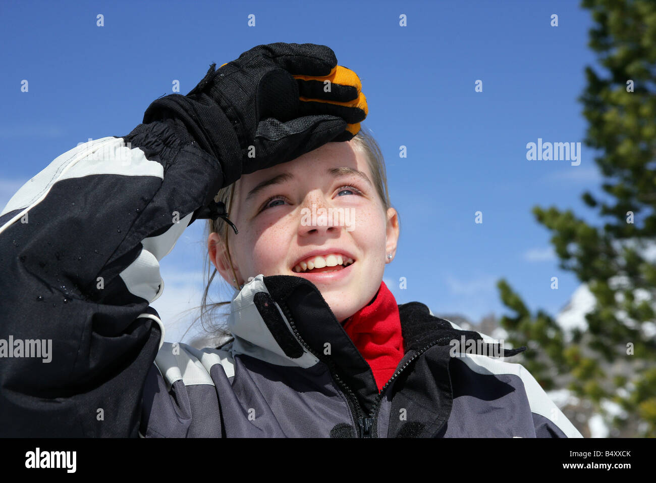 Girl wearing in jacket shielding eyes Stock Photo - Alamy