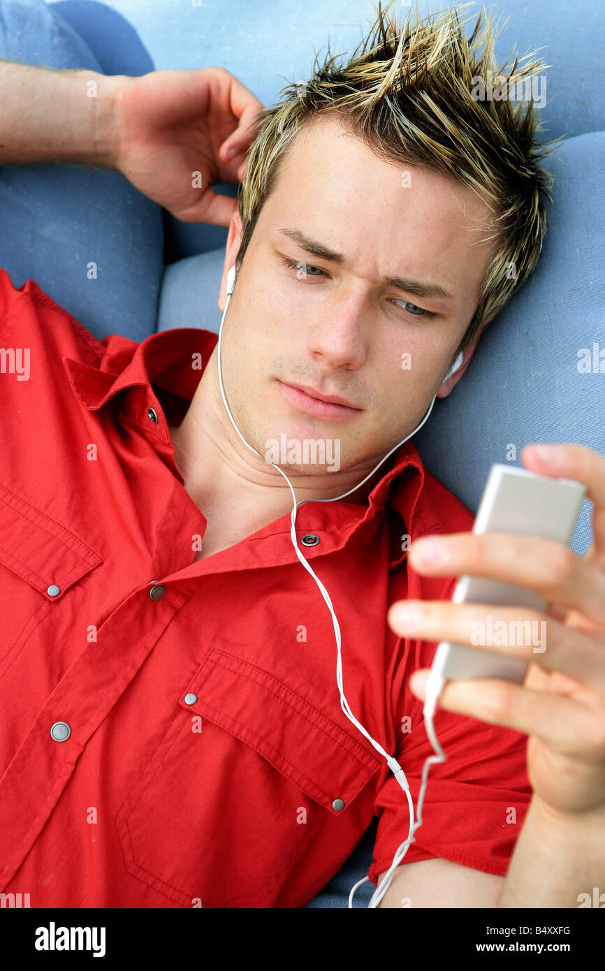 Young man listening to mp3 player, overhead view Stock Photo - Alamy