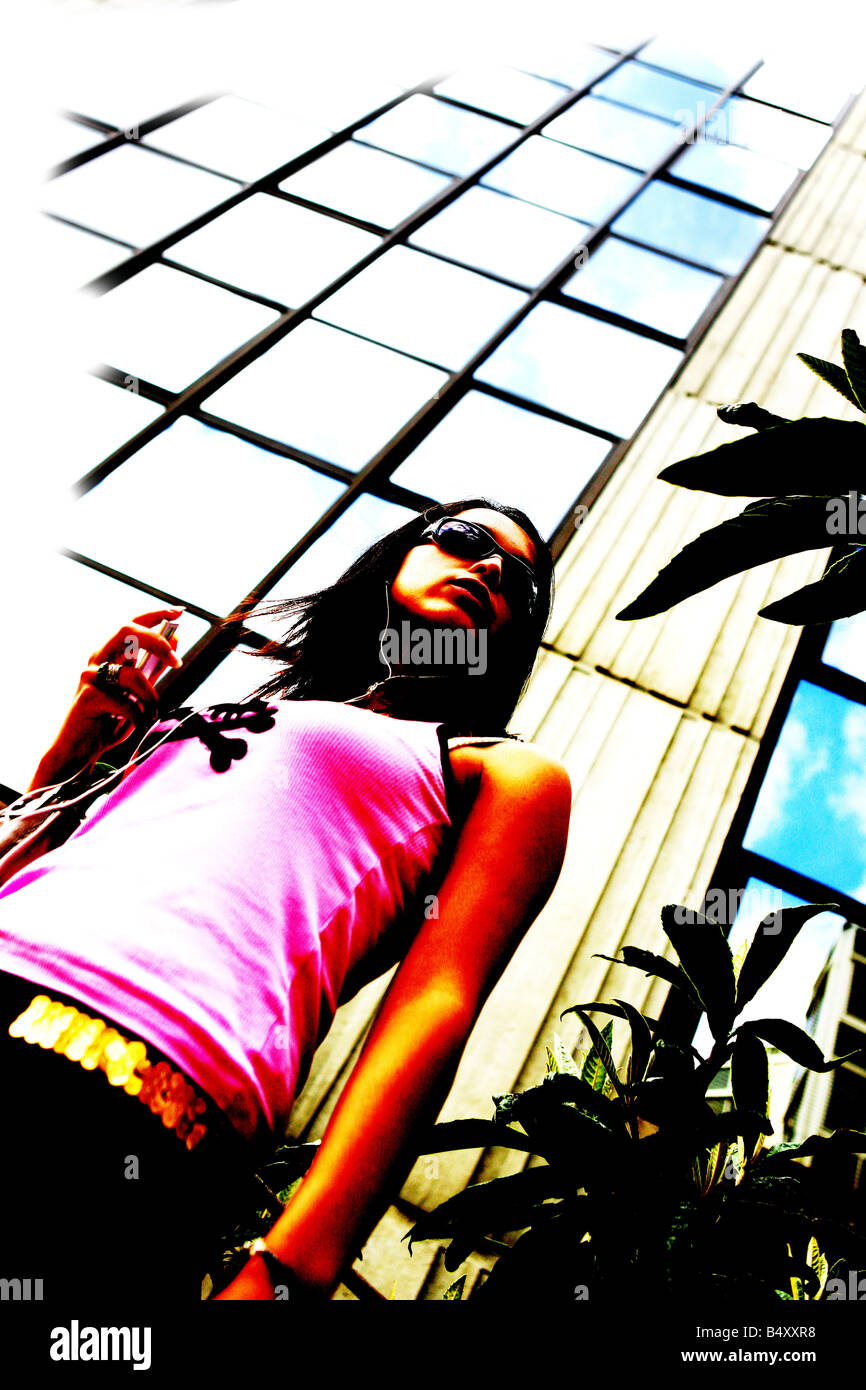 Young woman listening to music, low angle view Stock Photo - Alamy