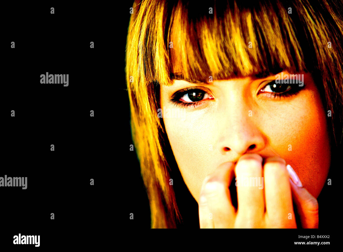 Young woman biting fingers, portrait Stock Photo - Alamy