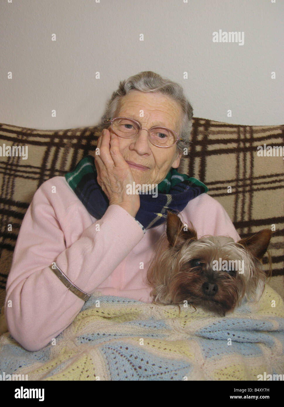 elderly woman keeping warm in winter wrapped up with rugs to save ...