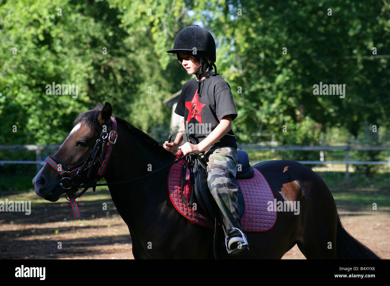 Boy riding horse, side view Stock Photo - Alamy