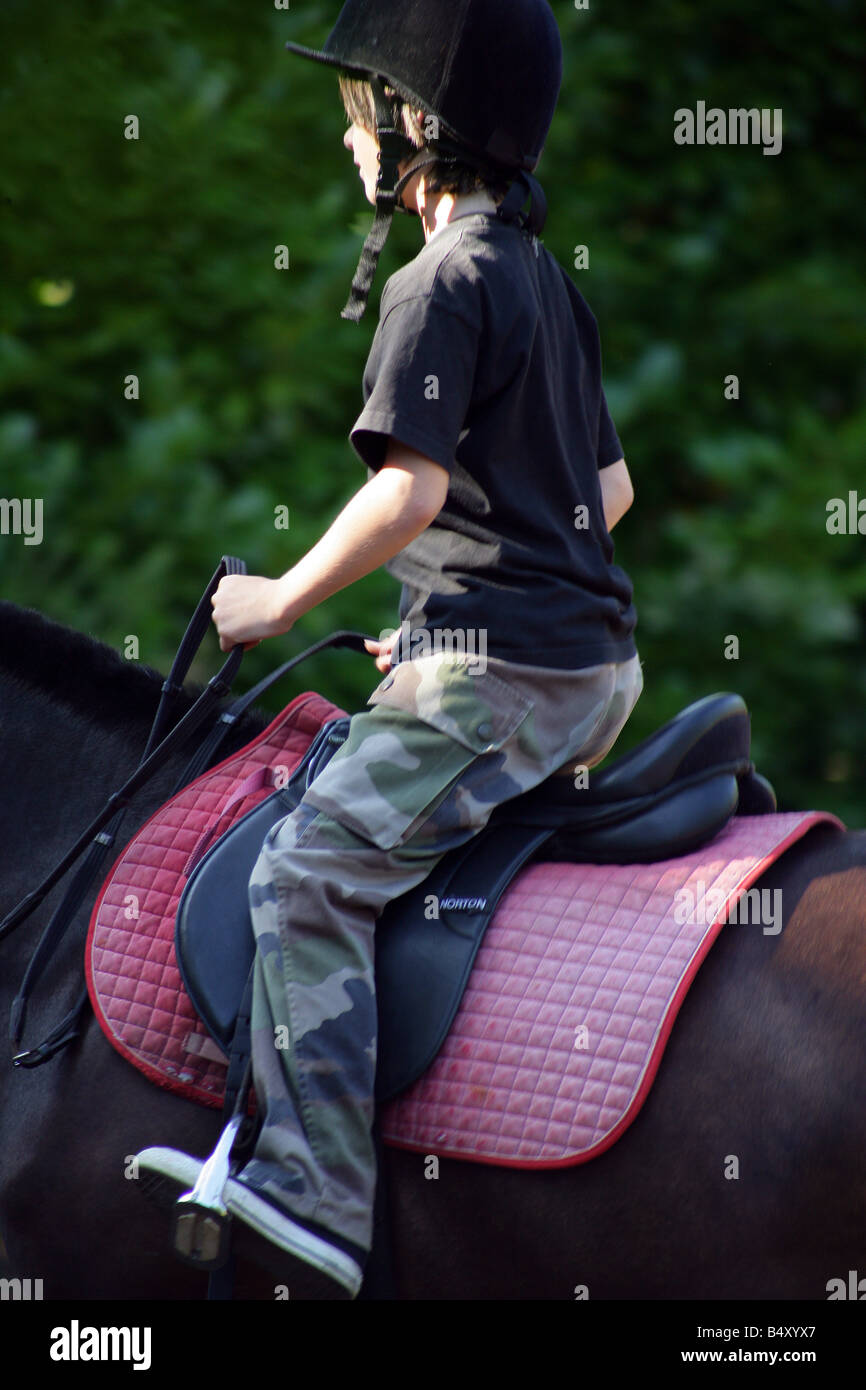 Boy riding horse, side view Stock Photo - Alamy