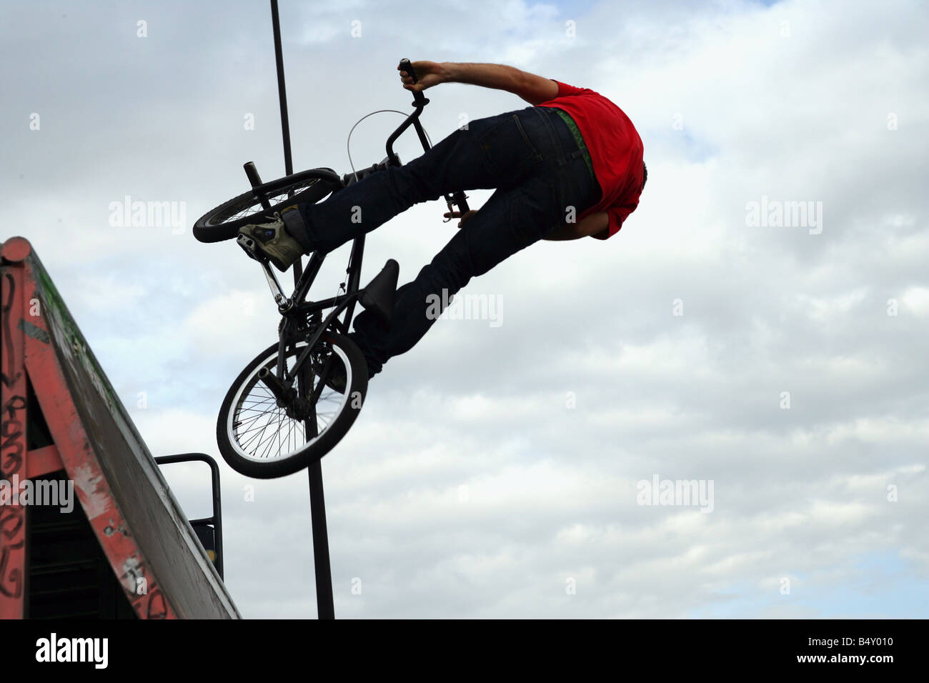 Young man performing stunt on bicycle Stock Photo - Alamy